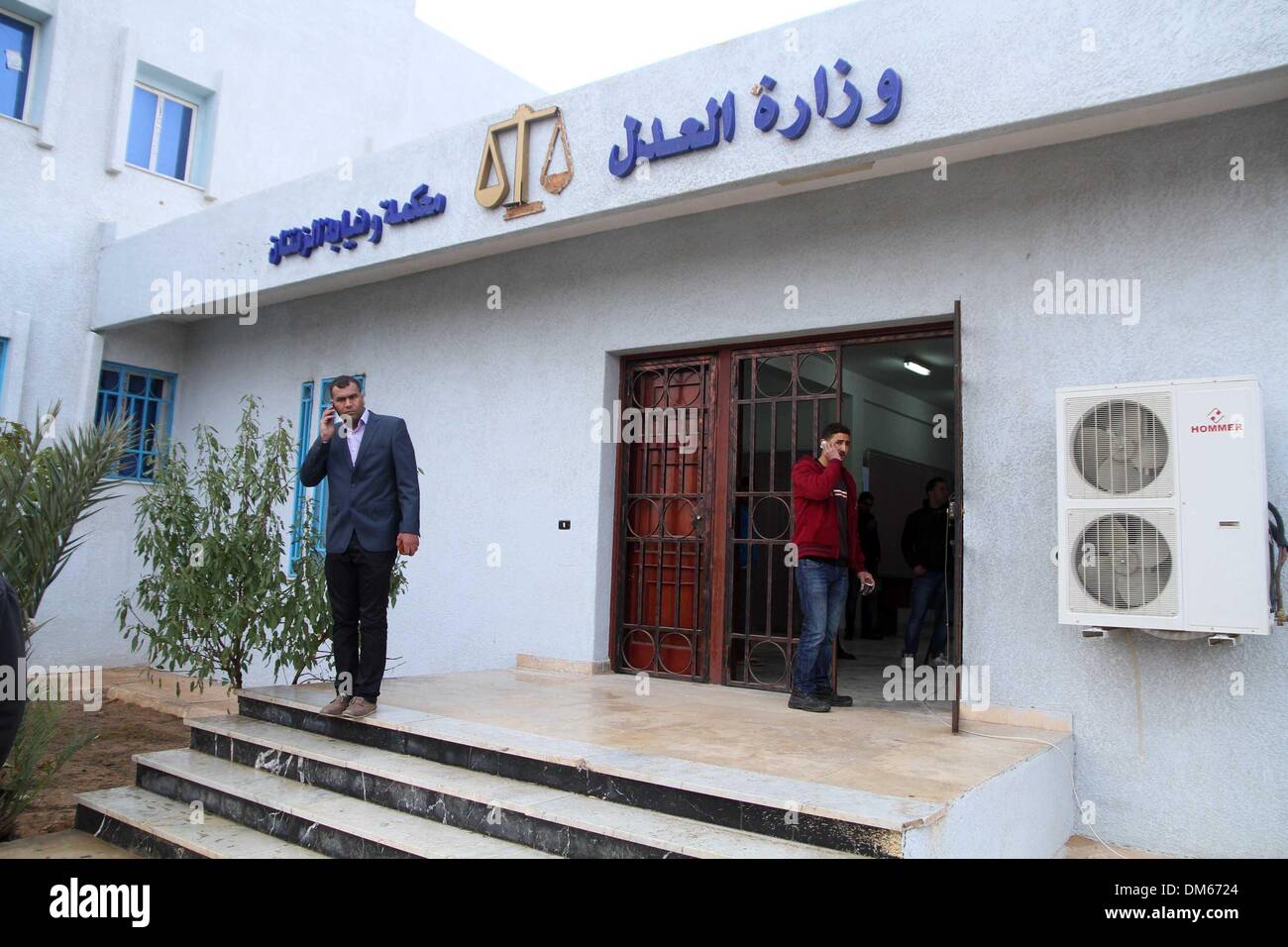 Zintan, Libya. 12th Dec, 2013. Libyans stand outside the court during a ...