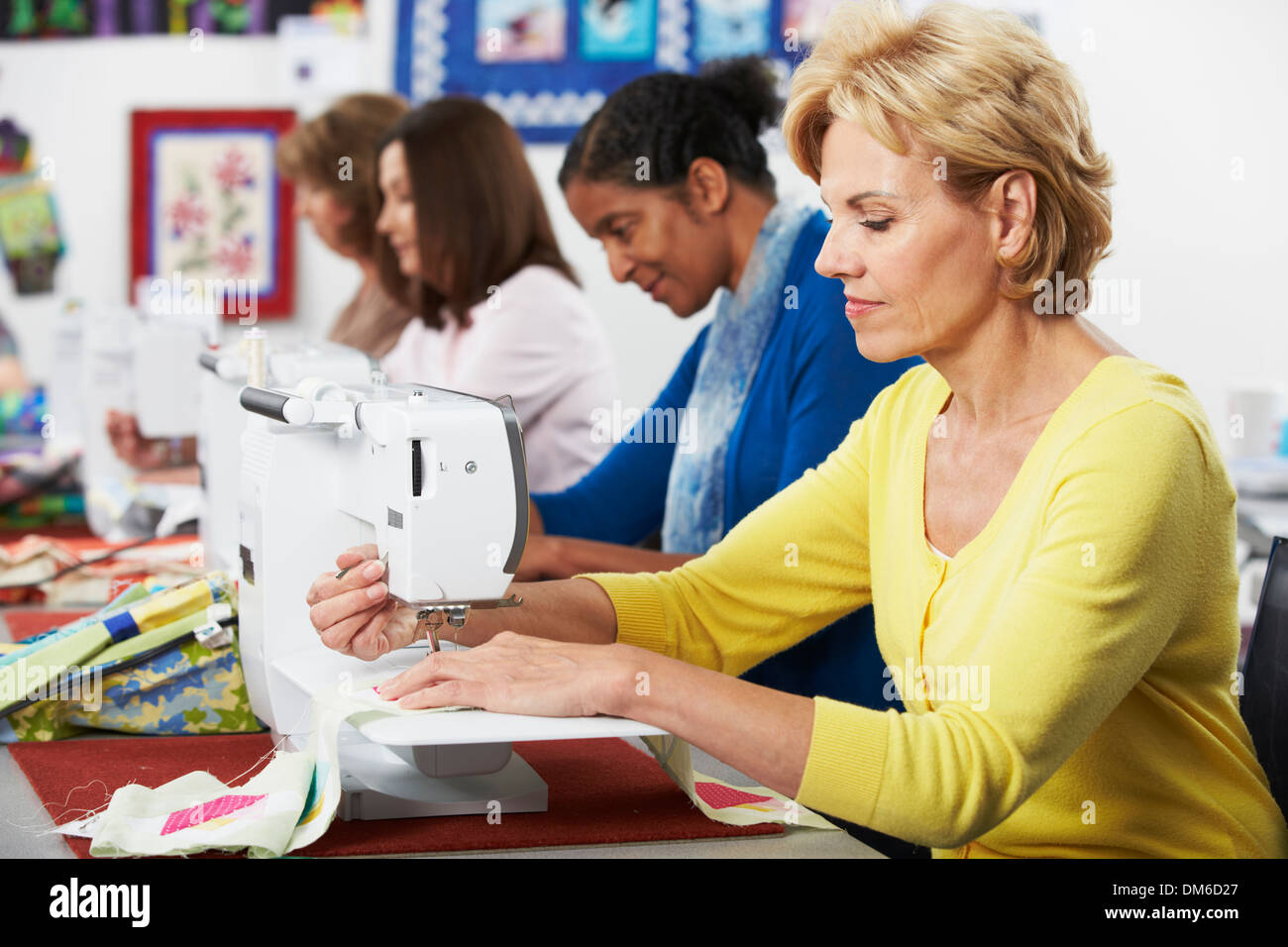 Group Of Women Using Electric Sewing Machines In class Stock Photo - Alamy