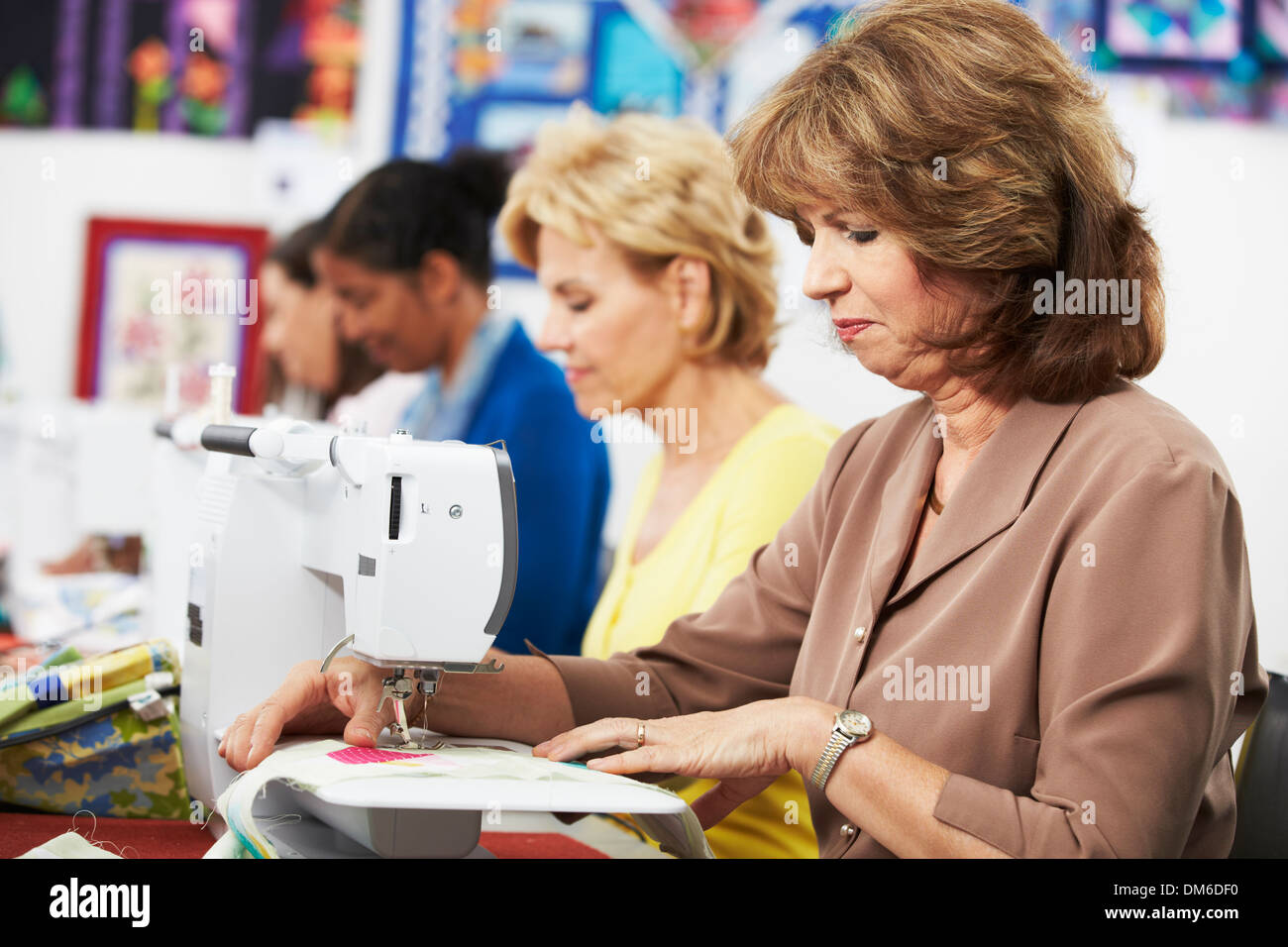 Group Of Women Using Electric Sewing Machines In class Stock Photo - Alamy