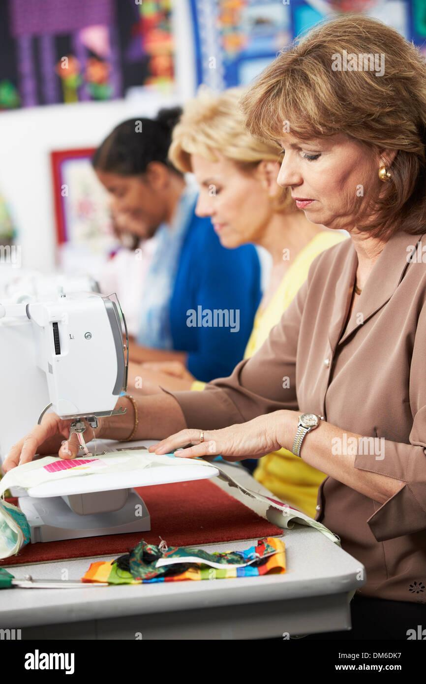 Group Of Women Using Electric Sewing Machines In class Stock Photo - Alamy