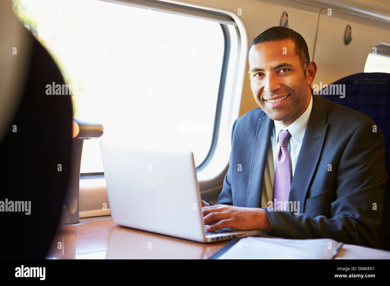 Businessman Commuting To Work On Train And Using Laptop Stock Photo - Alamy