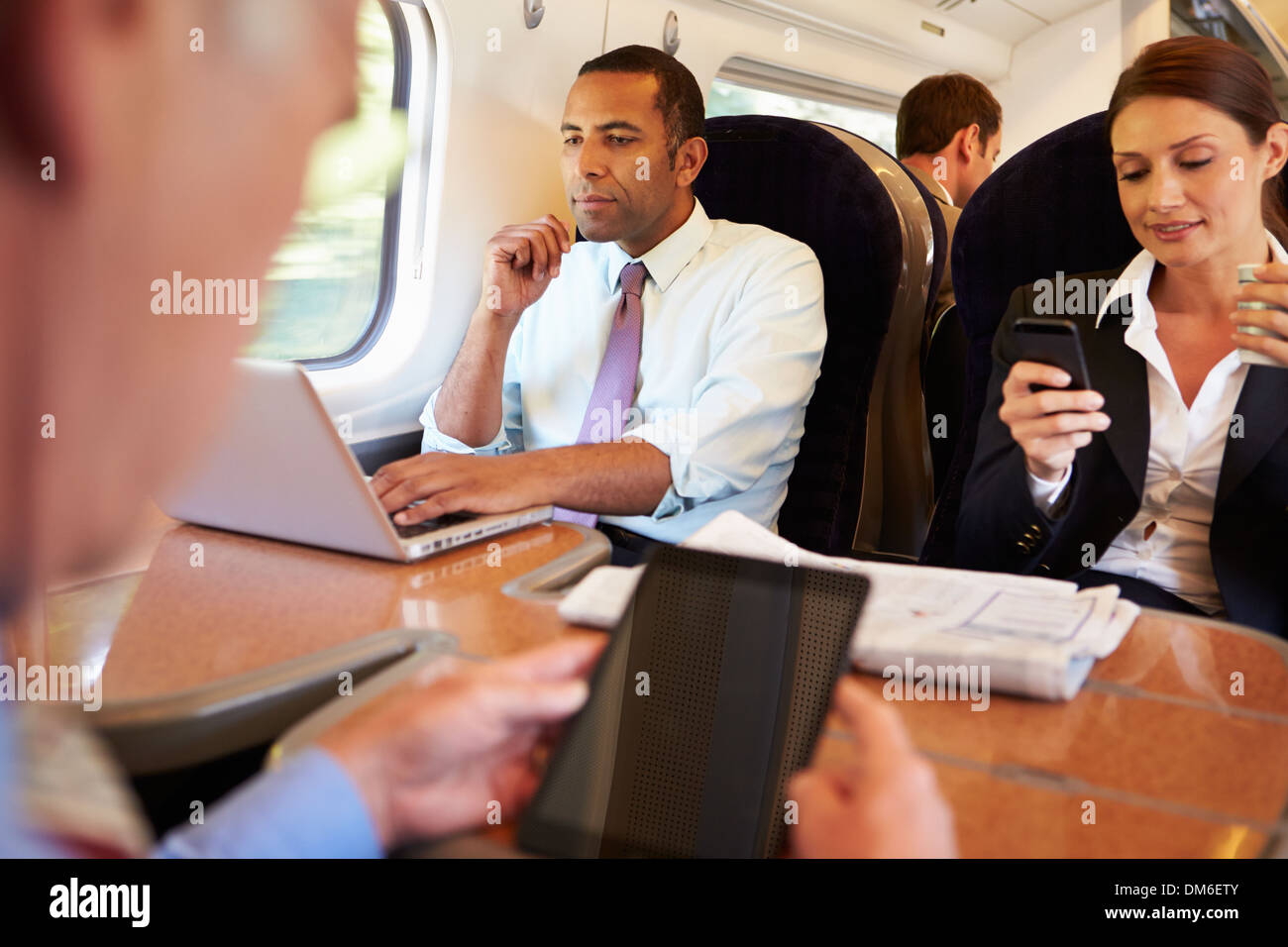 Businesspeople On Train Using Digital Devices Stock Photo - Alamy