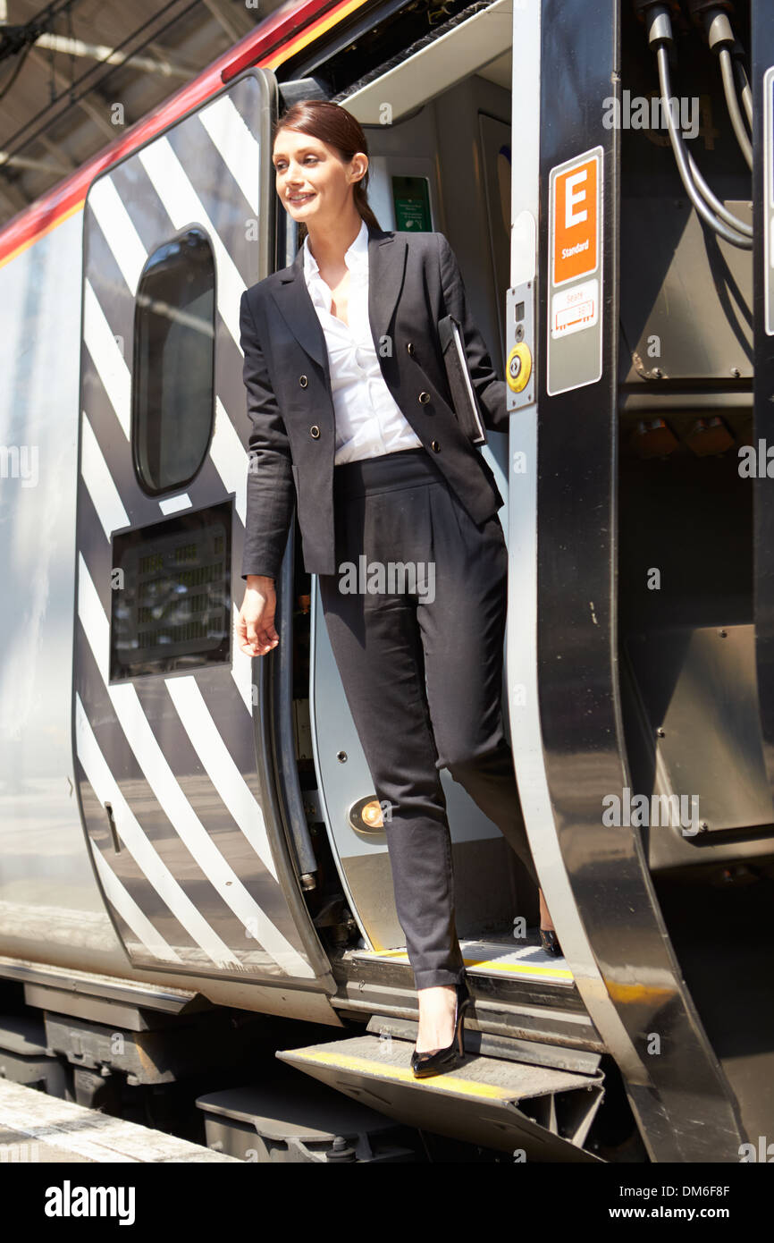 Businesswoman Getting Off Train At Platform Stock Photo - Alamy