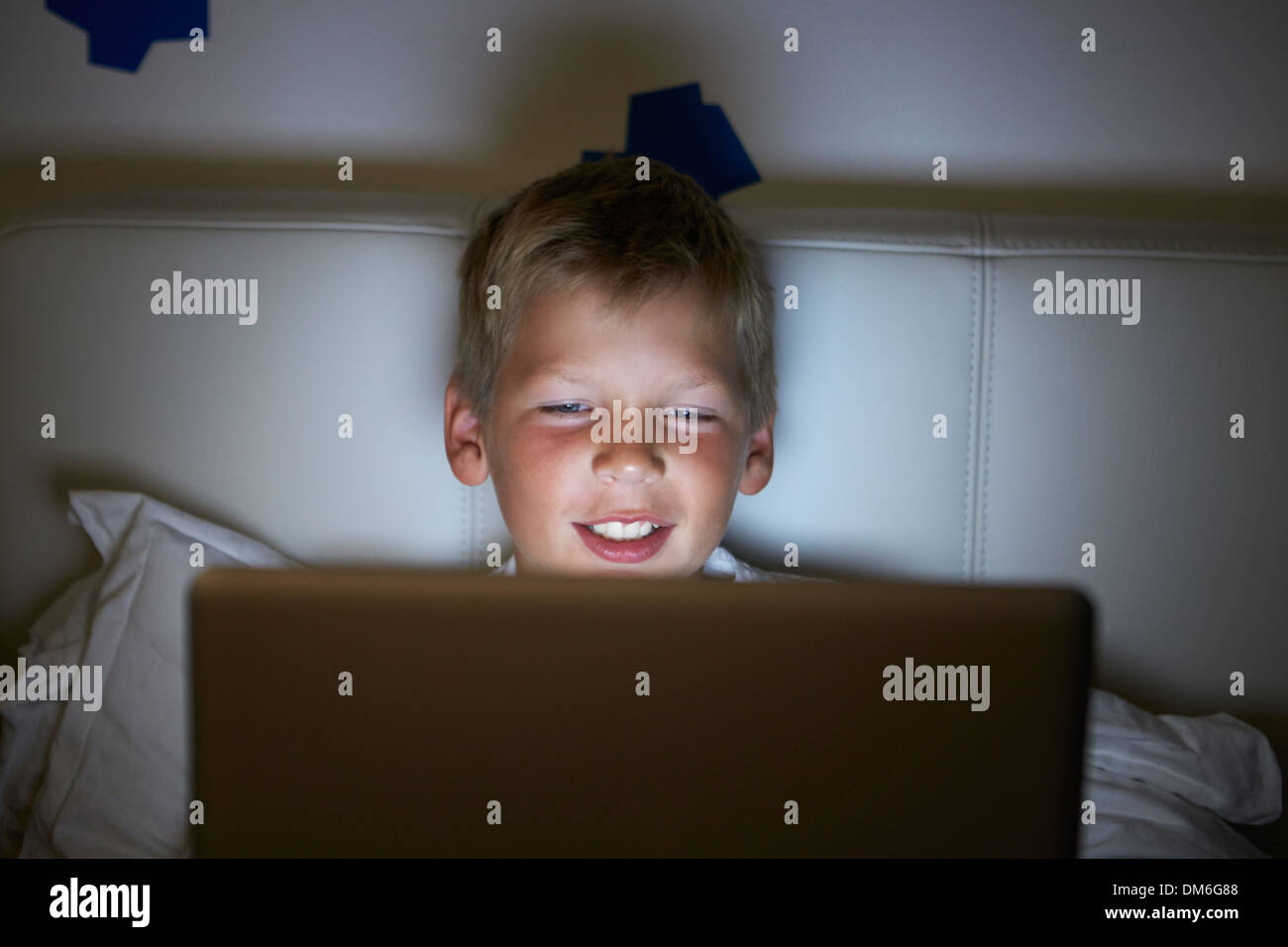 Boy Using Laptop In Bed At Night Stock Photo - Alamy