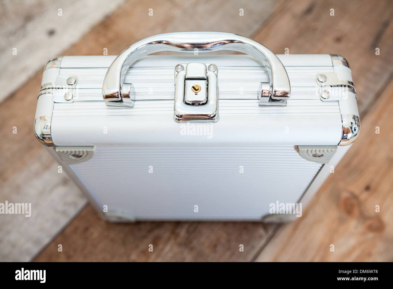 Closed steel case standing handle up on wooden floor Stock Photo - Alamy