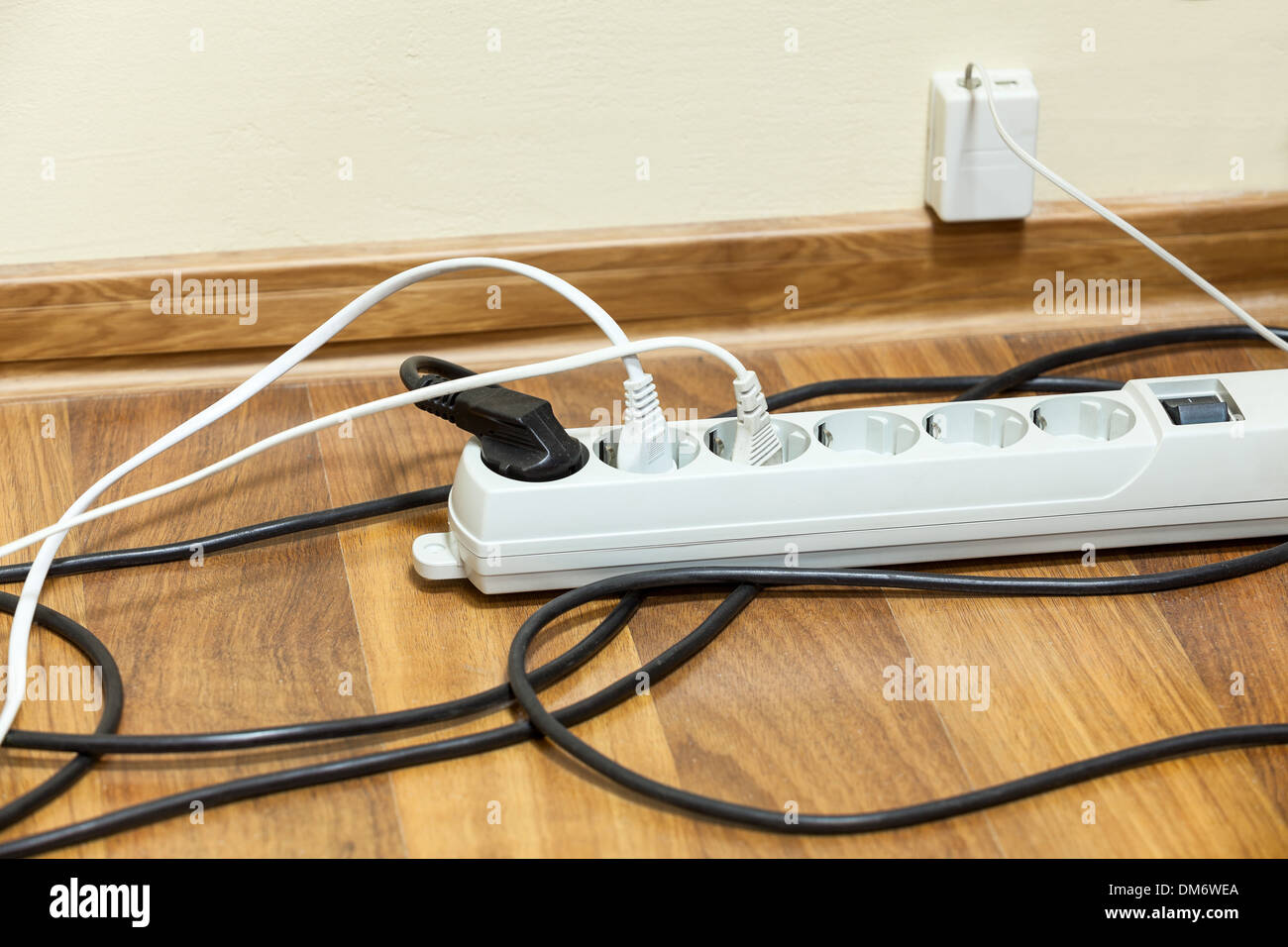 Many electrical cords connected to extension block on floor Stock Photo ...