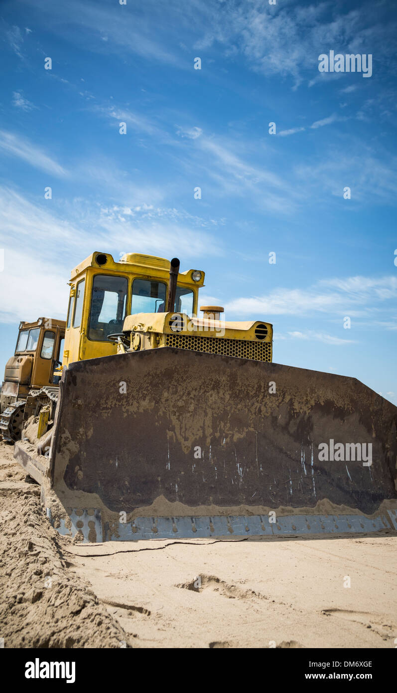 Bulldozer at work on blue sky background Stock Photo - Alamy