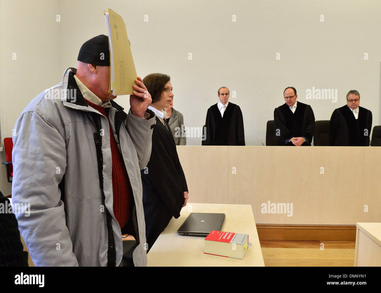 Defendant Ryszard Stanislaw W. from Poland holds a folder in front of ...