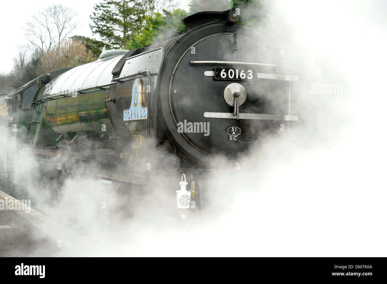 Steam train pulling away from station Stock Photo - Alamy
