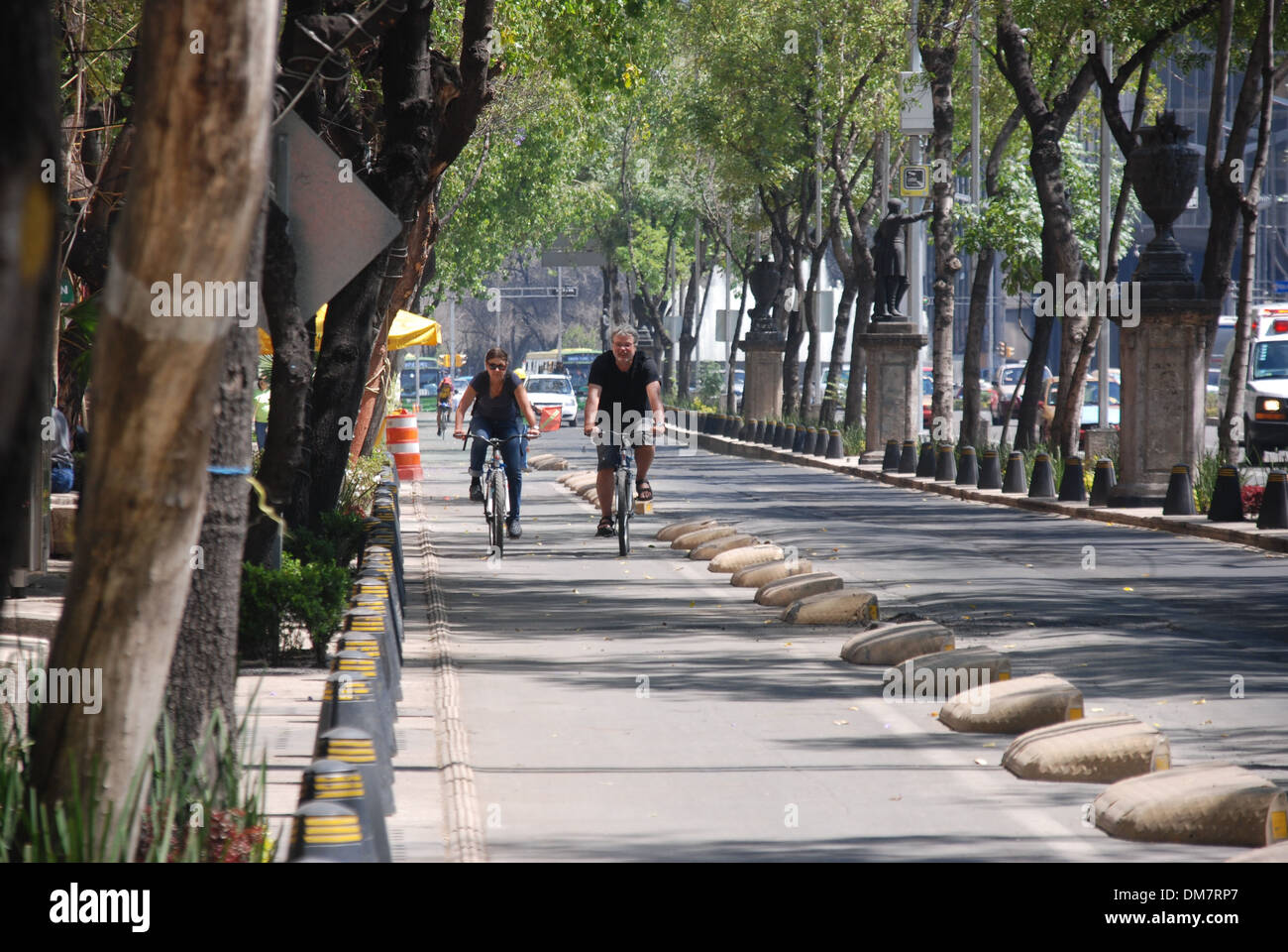 Two people riding their bikes on the bicycle lane enjoying the sun ...