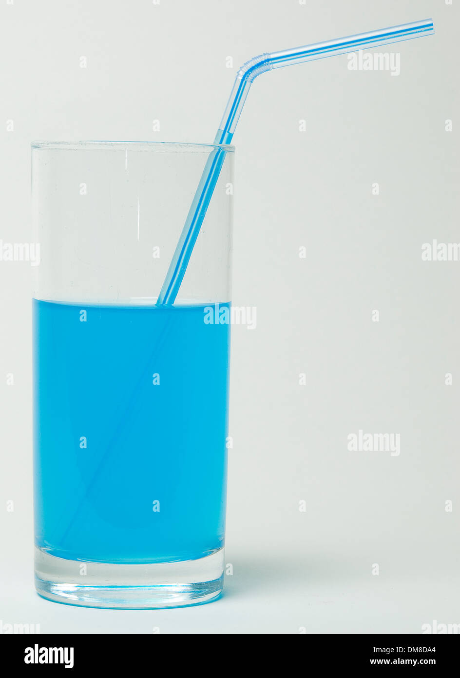Glass with a straw and blue liquid in it on a white background Stock ...