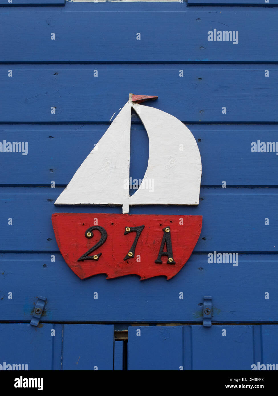 A ship shaped sign with the number 27A on a blue beach hut at ...