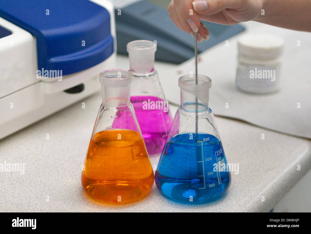 Flasks with colored chemicals and human hand Stock Photo - Alamy