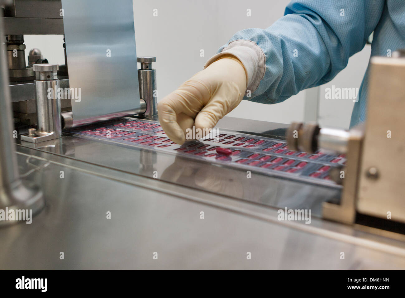 pharmaceutical production with blister packing machine and human hand ...