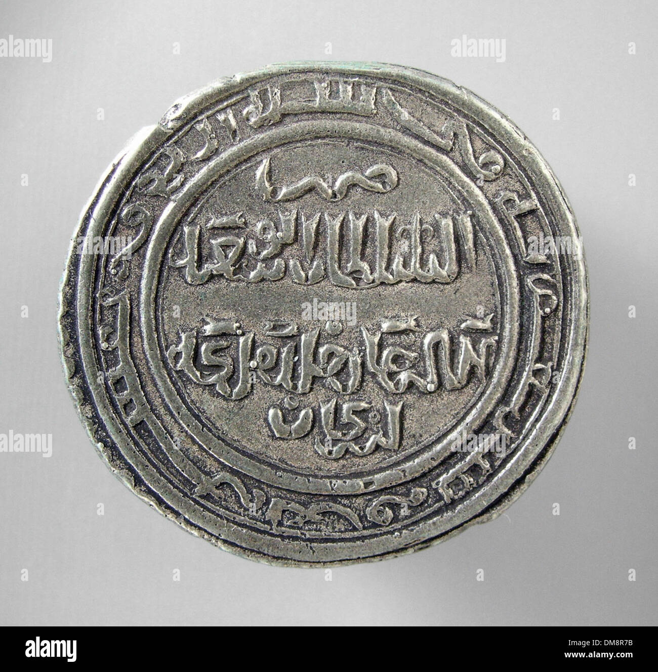 The Square-in-circle silver dirham, an ancient Islamic coin, reflects ...