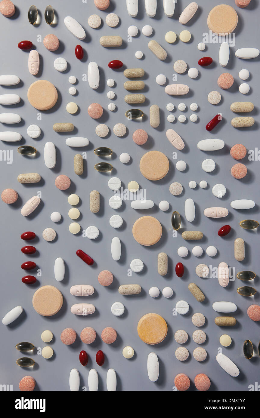 Assorted pills on a grey table Stock Photo - Alamy