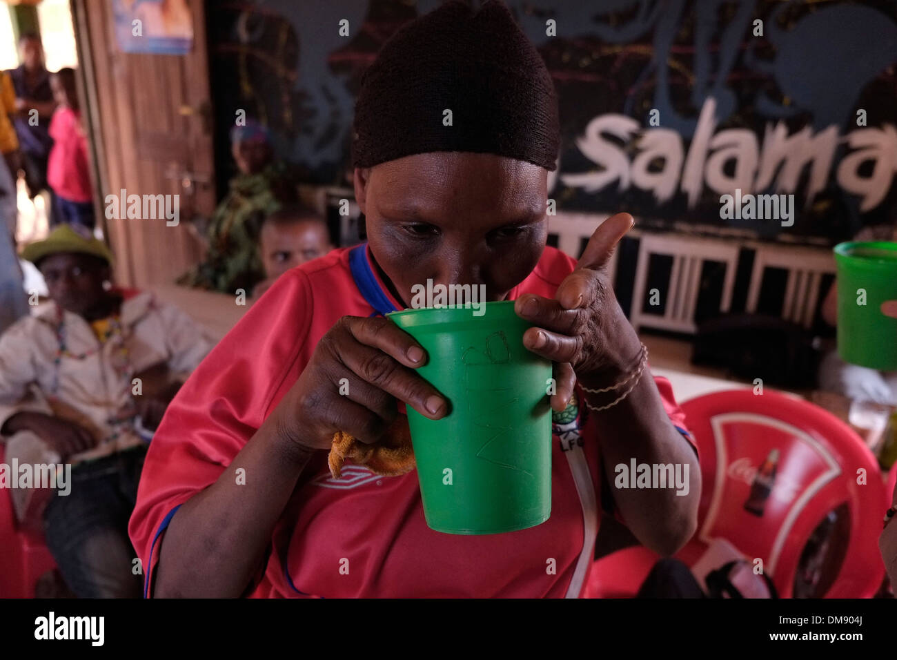 A woman drinking local beer in a bar in a village in the Arusha region ...