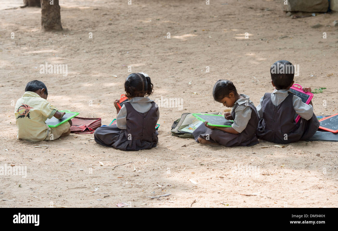 Rural Indian village school children in an outside class writing on a ...
