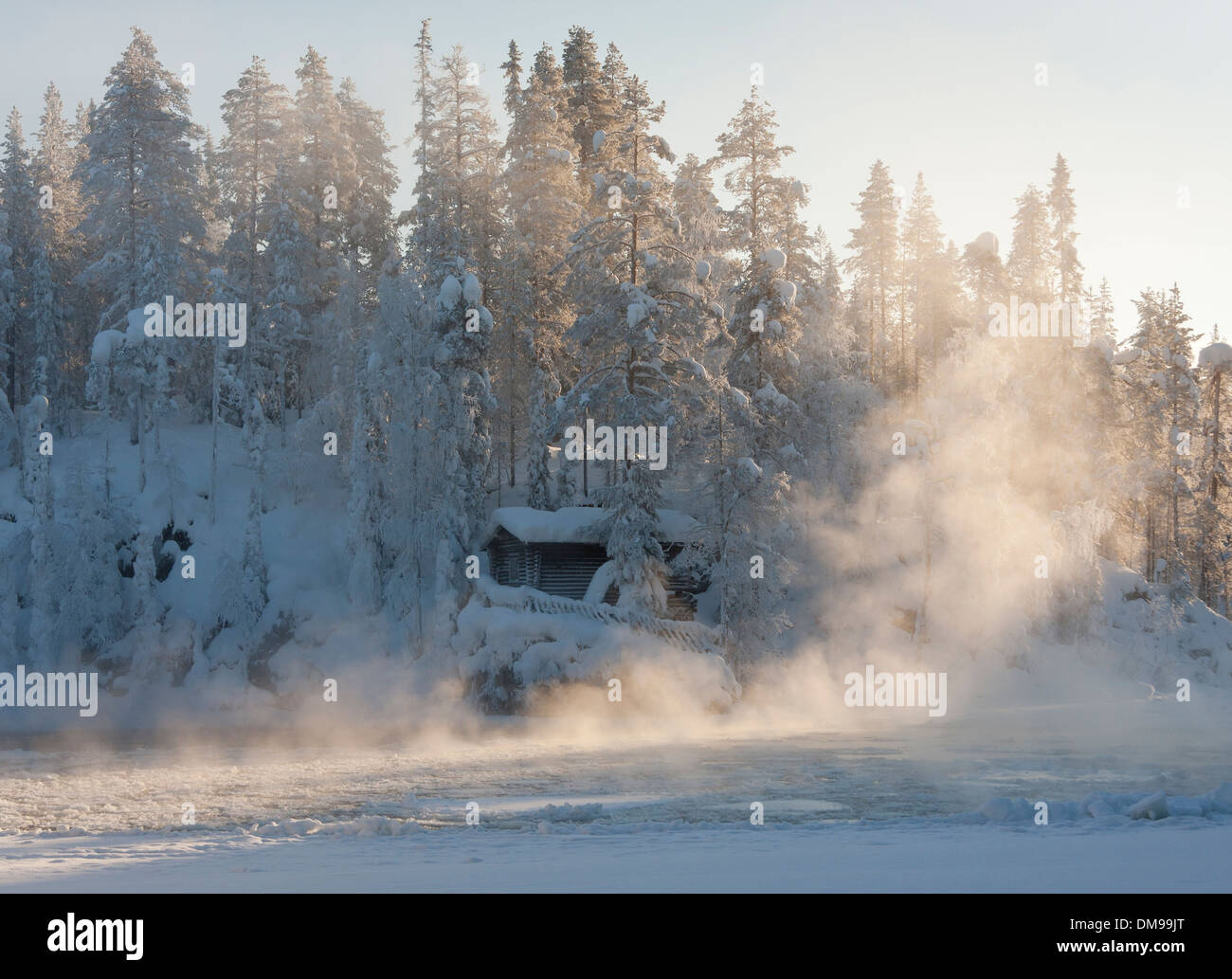 Small log cabin behind vaporing river in winter in Lapland, Finland ...
