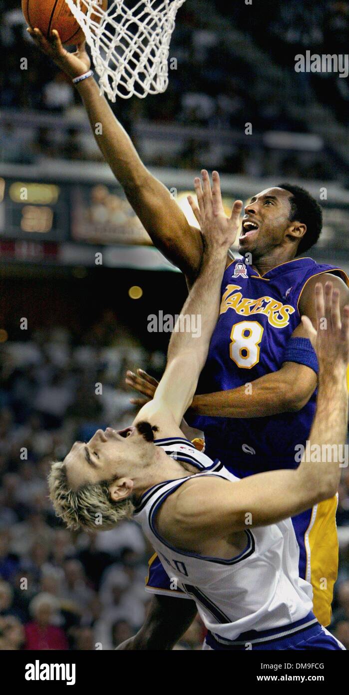 Kobe Bryant drives the lane toward the hoop with Scot Pollard defending ...