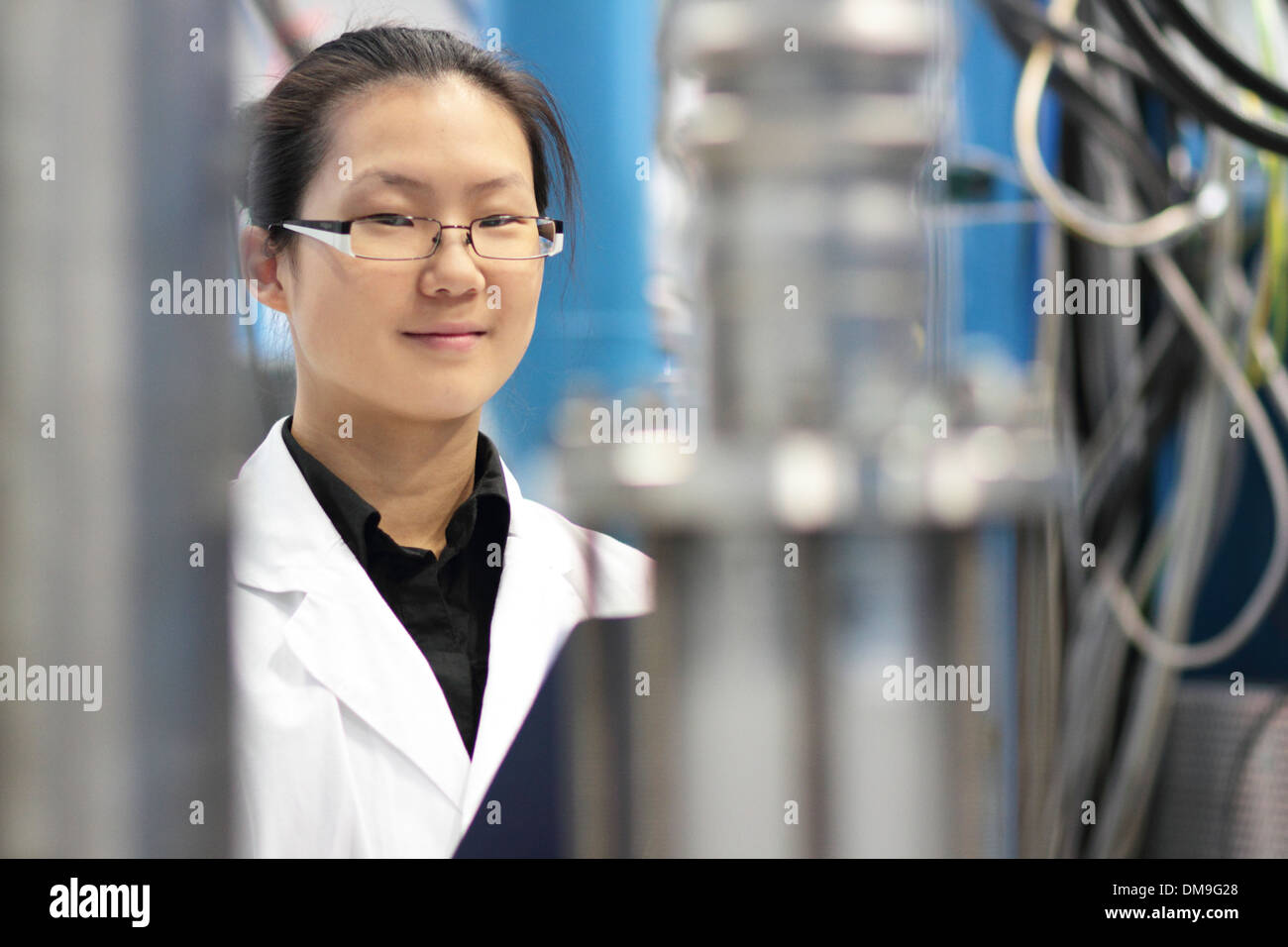 an asia woman scientist between a machine working and controlling a ...