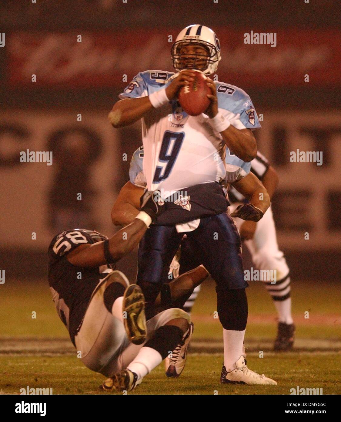 Tennessee Titan quarterback Steve McNair is spun around by Raider ...