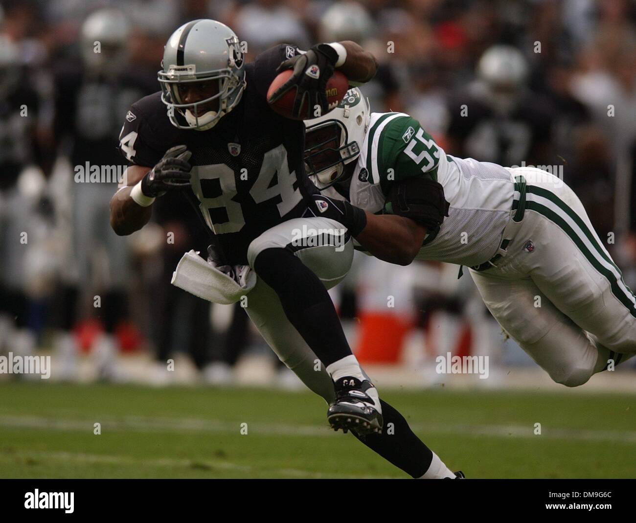 Raiders WR Jerry Porter makes a gain while dragging Jets Marvin Jones ...