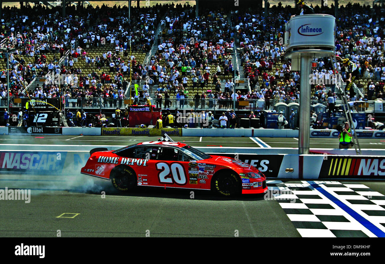 Tony Stewart carries the checkered flag across the start finish line at ...