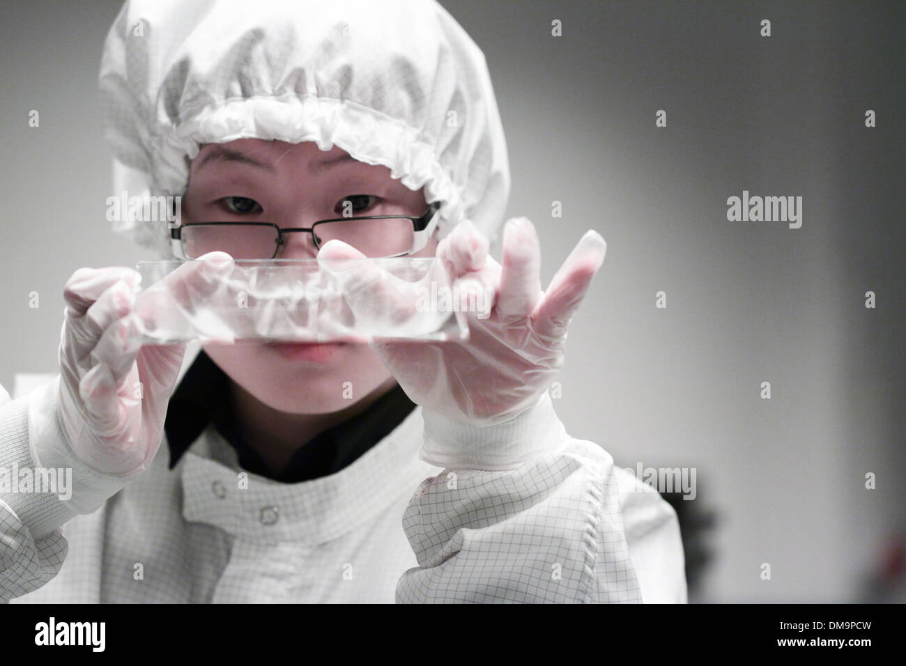 an asia scientist woman looking to a sample, carrying lab coat and lab ...