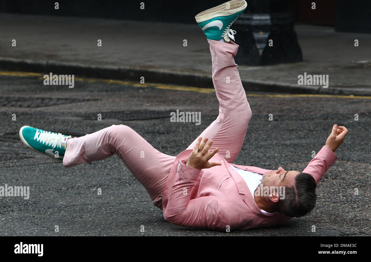 Robbie Williams performs a breakdance routine in a pink suit and ...