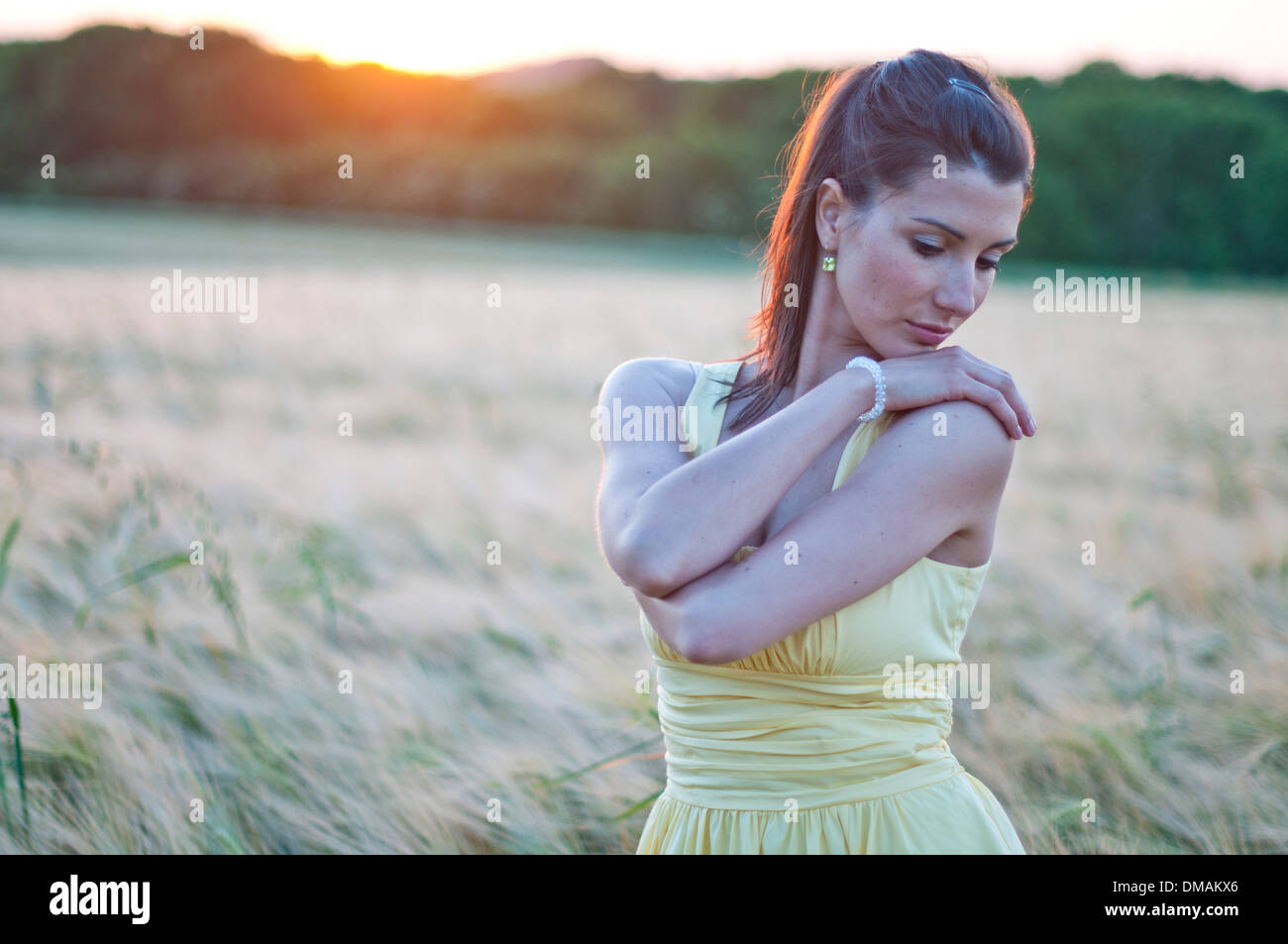 Young sad woman standing in a corn field at sunset Stock Photo - Alamy