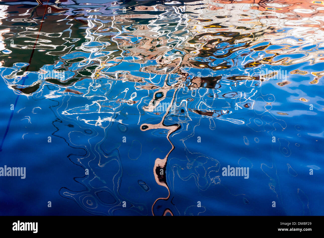Reflections of boat in blue water, ripples, calm Stock Photo - Alamy