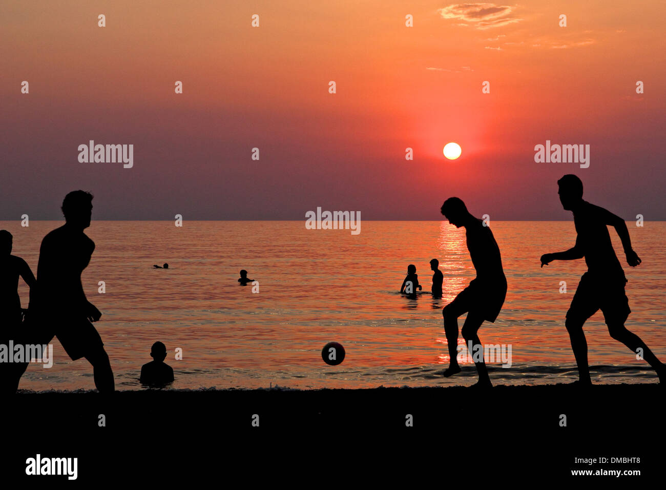 Silhouettes playing football during sunset Stock Photo - Alamy
