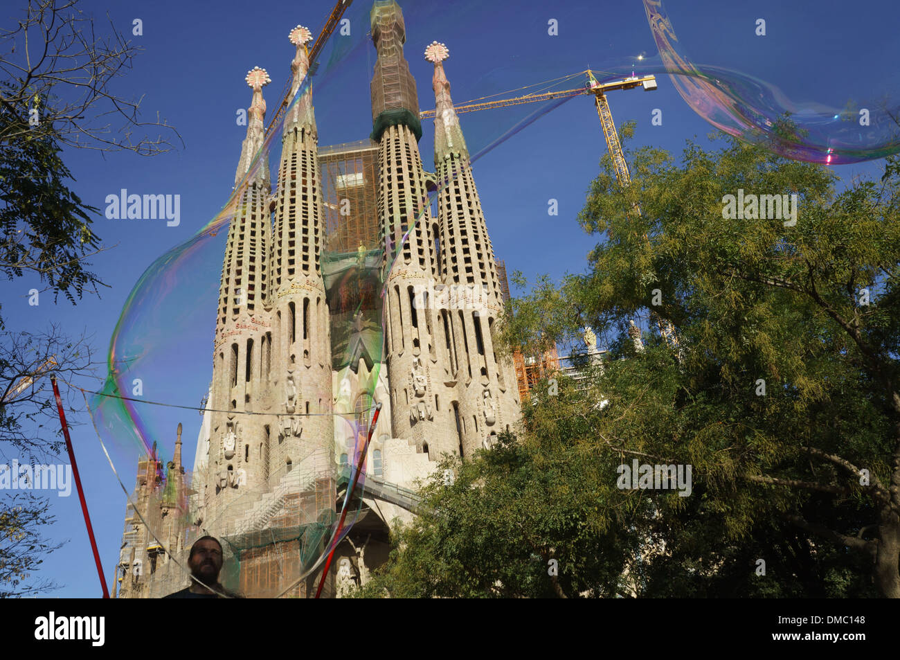 A man makes soap bubbles in front of Sagrada Familia, masterpiece of ...