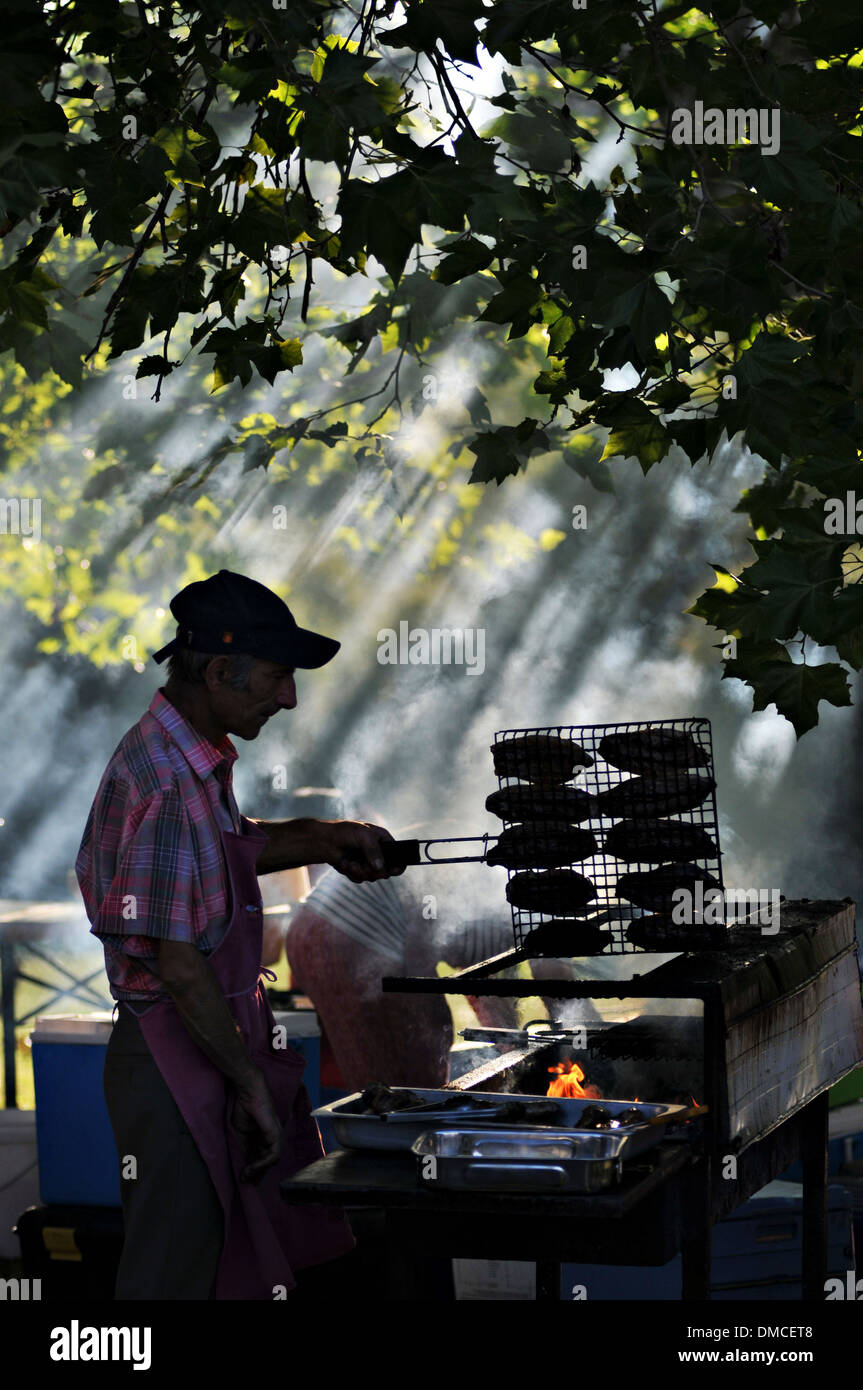 A barbecue chef checks the food in the summer sunshine Stock Photo - Alamy