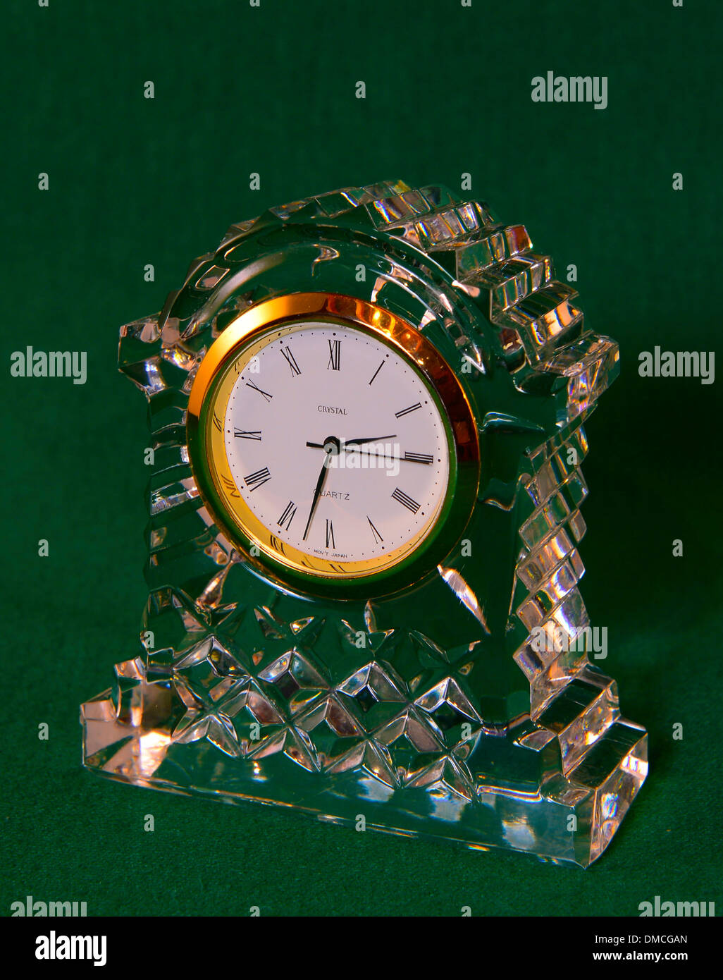 crystal table clock with gold ring and green background Stock Photo - Alamy