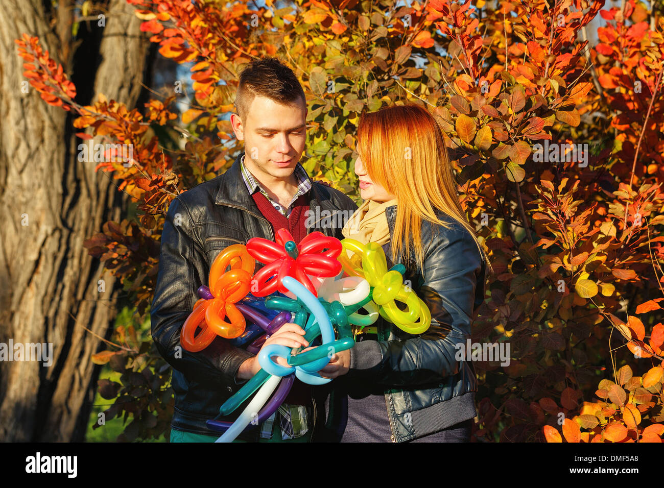Young couple tenderly and lovingly looking at each other in autumn park ...