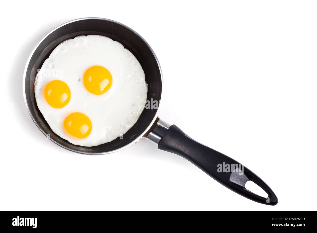 three fried egg on teflon pan without oil isolated on white Stock Photo ...