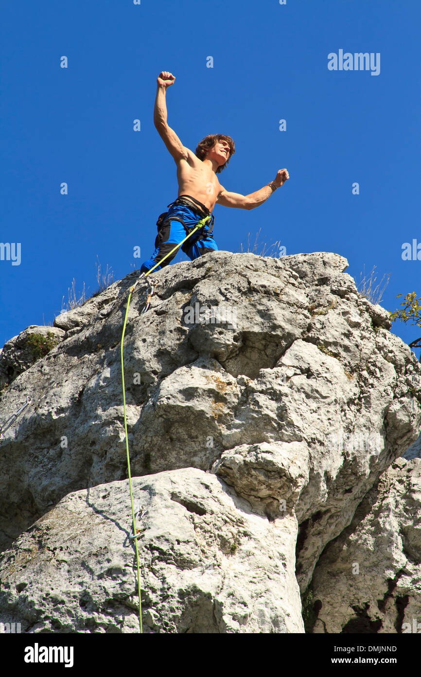 Rock climber celebrating on a top of limestone cliff after successful ...
