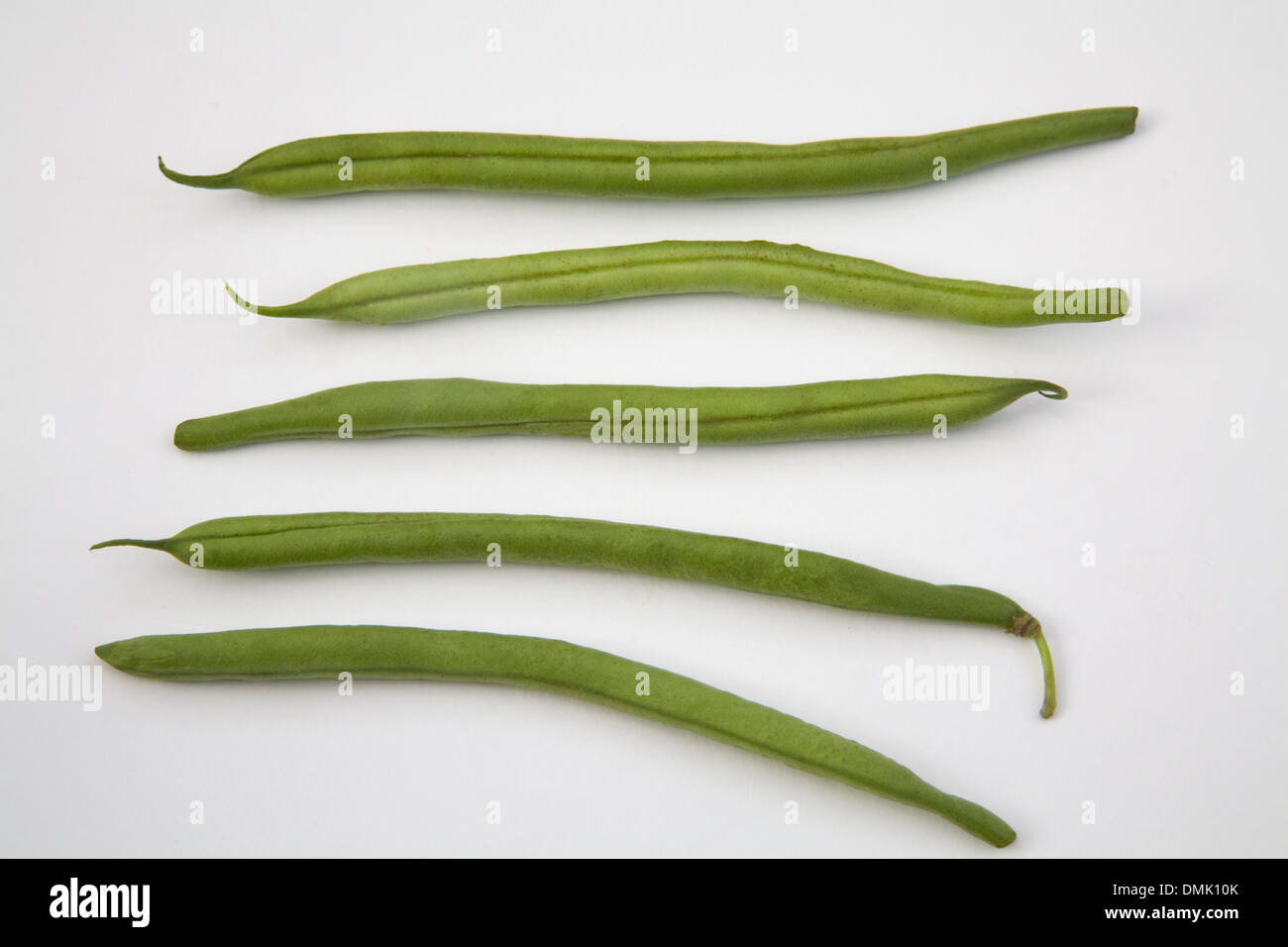 Close up five fine green beans on white background Stock Photo - Alamy
