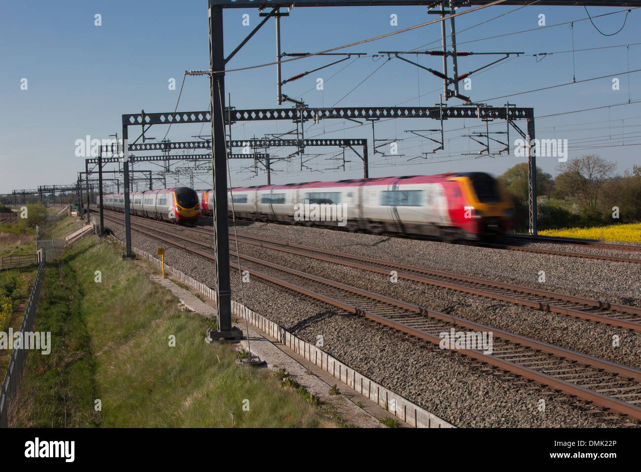 Two Virgin passenger trains speed along the West Coast Main Line ...
