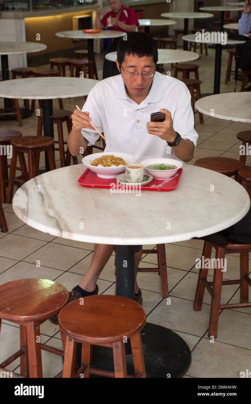 BUSINESSMAN HAVING LUNCH ON THE RUN AT A SIDEWALK CAFE AT THE LAU PA ...