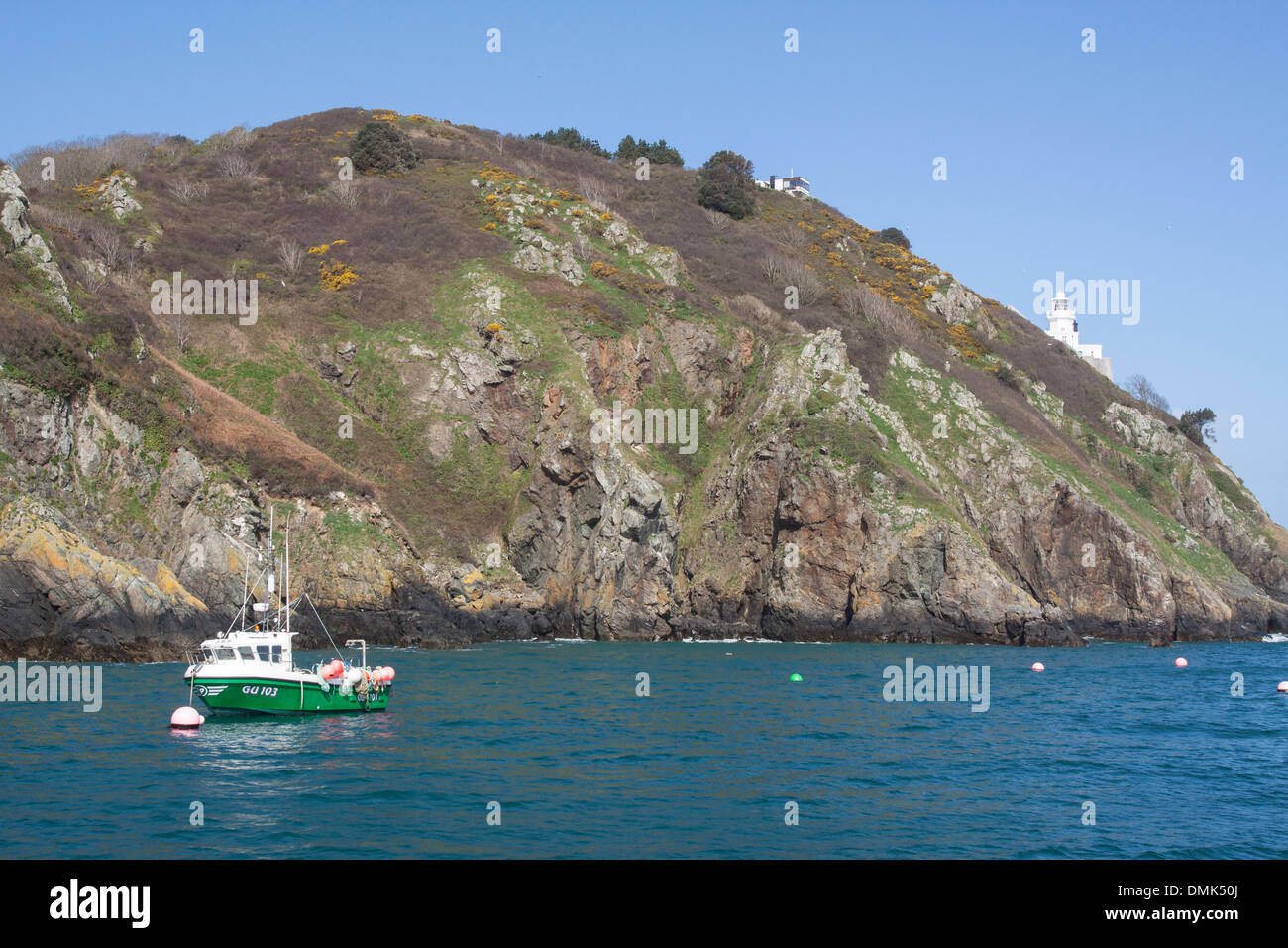 FISHING BOAT CASTING NETS NEAR THE ENTRANCE TO THE PORT OF SARK, ISLAND ...