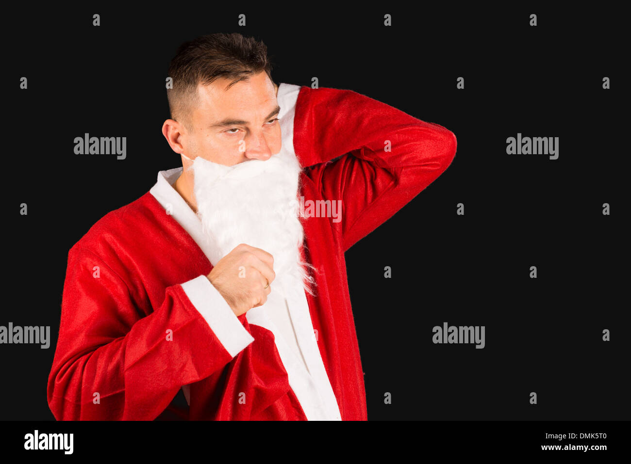 Guy putting on the Santa disguise beard, not very happy about it Stock ...