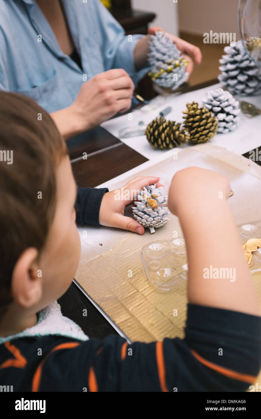 Little boy and his mother are painting pine cones for Christmas Stock ...