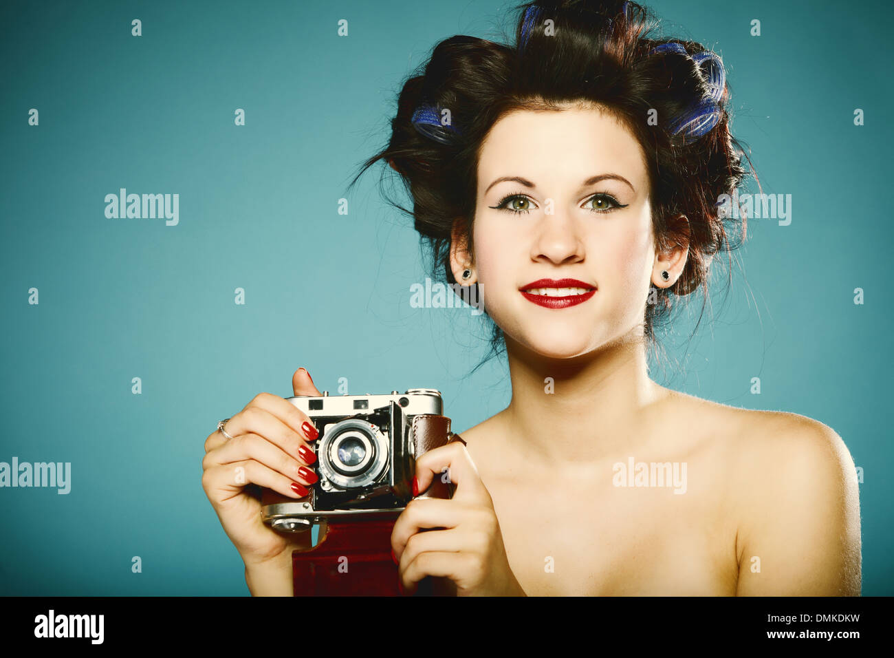 pretty retro girl taking picture using vintage camera blue background ...