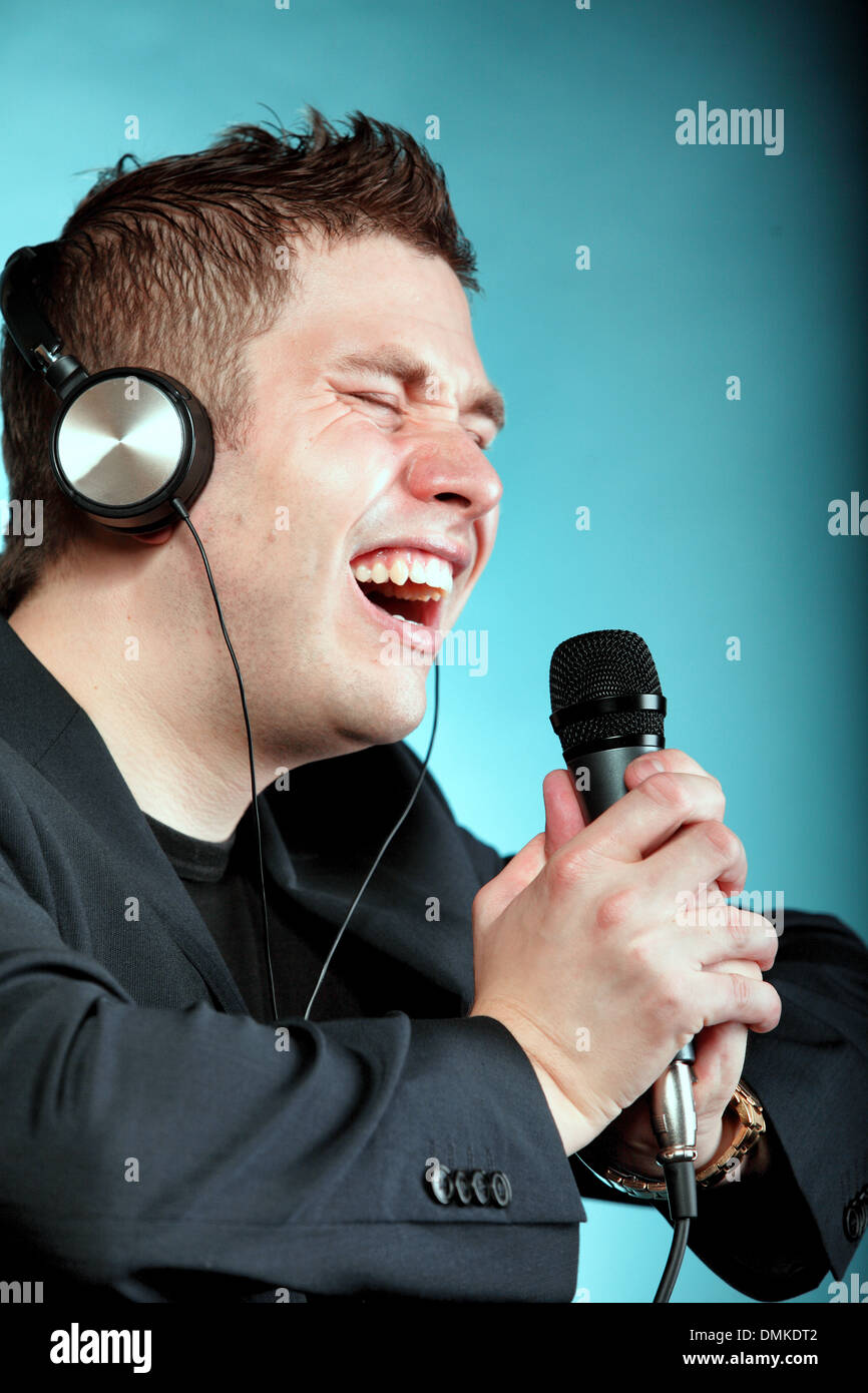 Man singing into microphone happy karaoke signer Stock Photo - Alamy