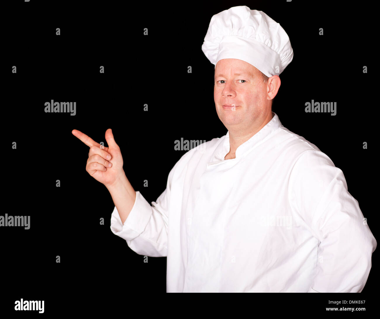 Male chef pointing on isolated black background Stock Photo - Alamy