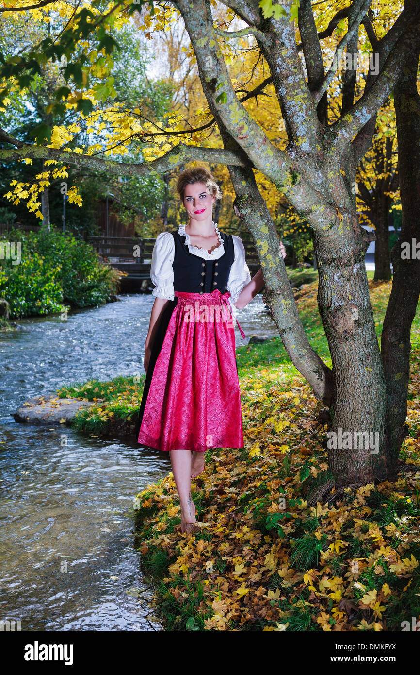 Beautiful woman in a dirndl under an autumn tree Stock Photo - Alamy