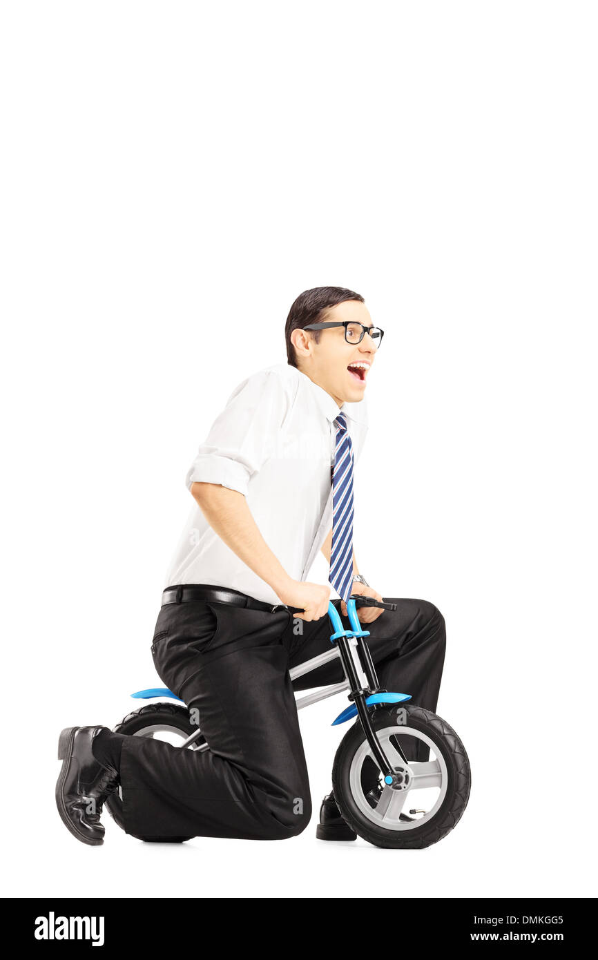 Excited young businessperson riding a small bicycle Stock Photo - Alamy